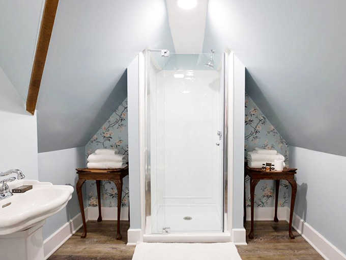 Clever design transforms this attic bathroom into a spa-like retreat, with a modern shower nestled perfectly under the sloped ceiling.