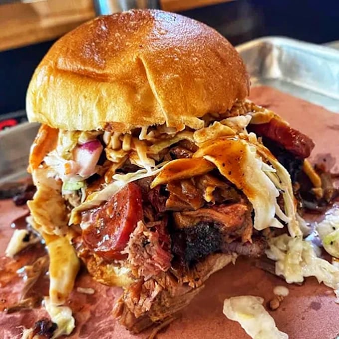 Not just a sandwich, but a skyscraper of smoky, juicy brisket that requires both hands, several napkins, and absolutely no shame.