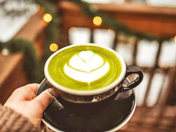 The vibrant green matcha latte arrives with a delicate heart design &ndash; proof that art and devotion still flourish within these historic walls.