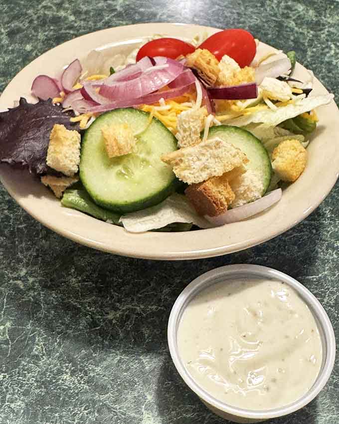Even the humble side salad gets the royal treatment with crisp cucumbers, vibrant tomatoes, and house-made croutons.