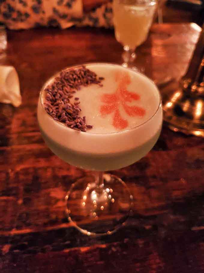 This Pisco Sour arrives with artistic flair &ndash; lavender buds line one side of its frothy top while a delicate pattern adorns the other.