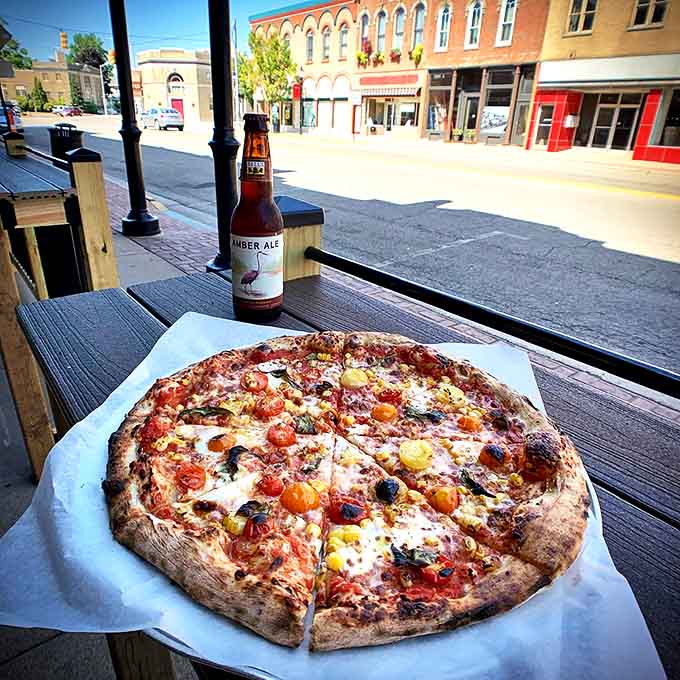 A perfect circle of culinary artistry &ndash; this wood-fired pizza with colorful heirloom tomatoes pairs beautifully with a local amber ale on the patio.