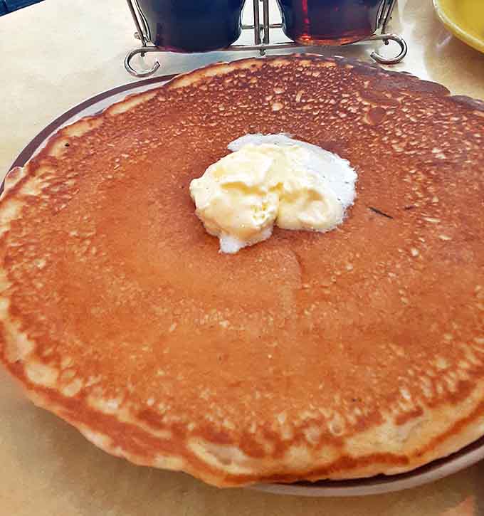 A perfect golden disc with melting butter creating a heavenly pool in the center&mdash;breakfast engineering at its finest.