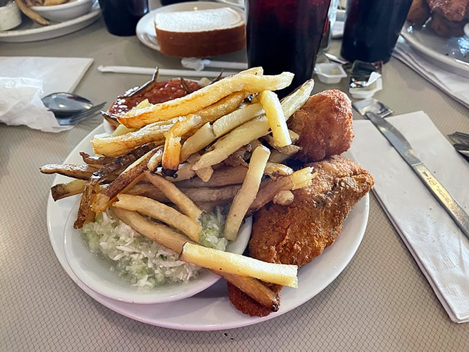 The Regular Chicken Dinner showcases perfectly fried pieces alongside crispy fries and creamy coleslaw &ndash; comfort food elevated to an art form.