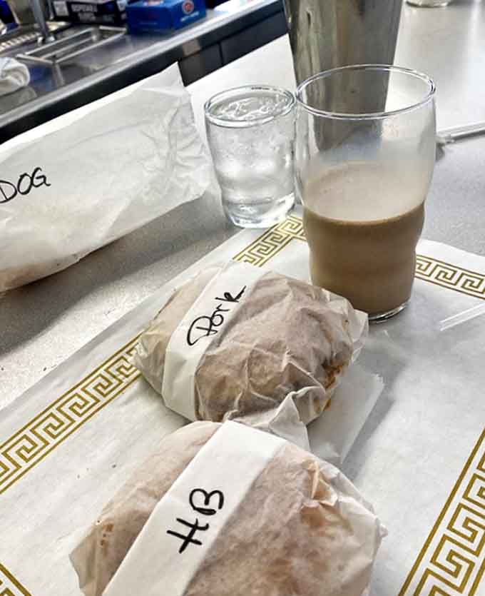 The holy trinity of diner bliss: wrapped sandwiches, a creamy milkshake, and that classic paper placemat that's seen more meals than most food critics.