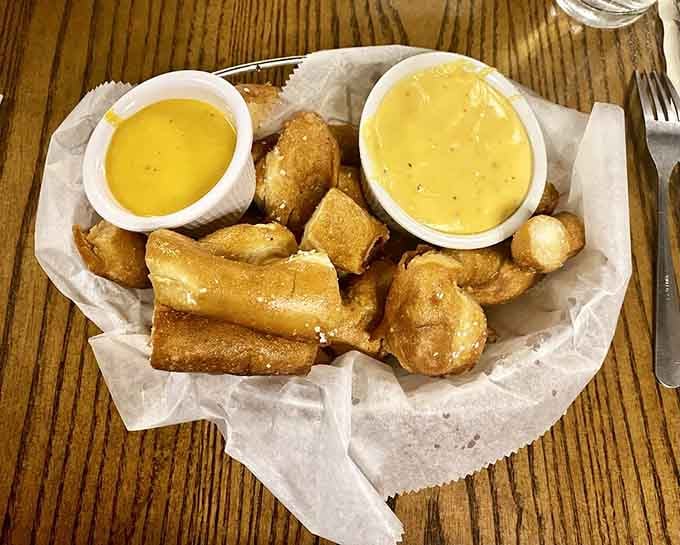 Golden pretzel nuggets arrive hot with cheese sauce, proving that carbs and dairy make the world go round, or at least your stomach happy.