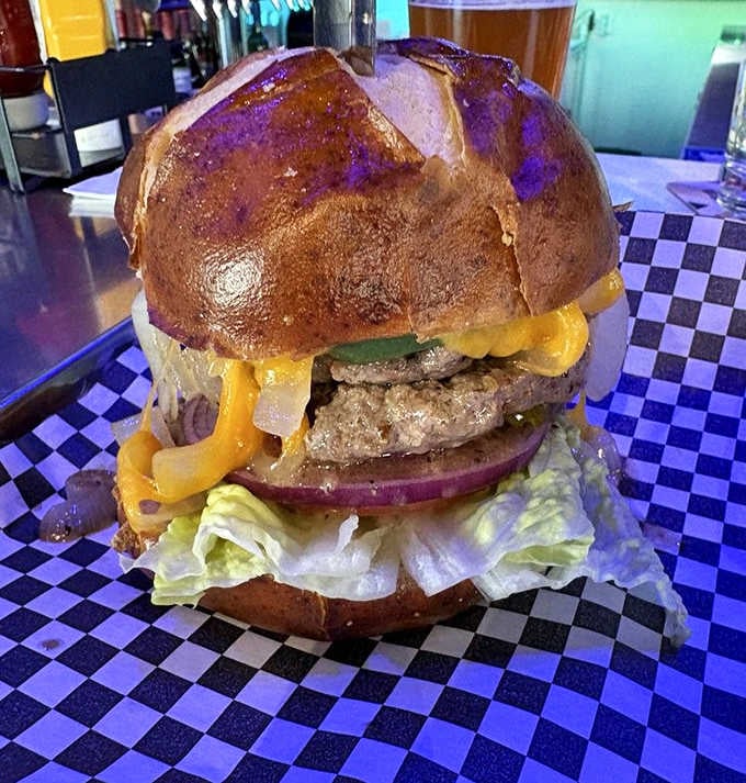 A perfectly caramelized patty on a pretzel bun with melty cheese cascading down the sides &ndash; burger architecture at its finest.