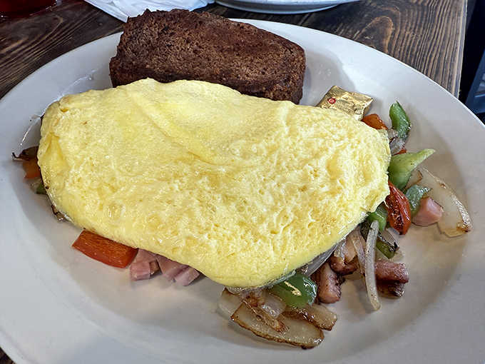 Steak Omelette: Breakfast of champions or hangover cure? This fluffy yellow miracle with its hearty fillings and side of rye toast works magic either way.