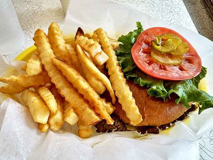 A classic cheeseburger done right – juicy patty, fresh toppings, and those crinkle-cut fries that somehow taste better in a diner.