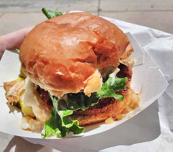 Lettuce, pickle, and a perfectly toasted bun cradle a hand-formed patty – burger architecture at its most fundamentally perfect.