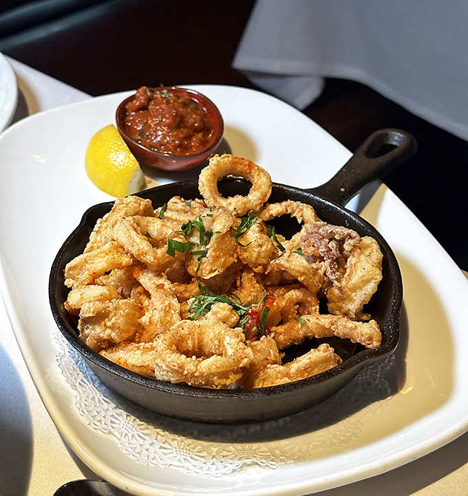 Crispy calamari arrives sizzling in its cast-iron skillet, a testament to the kitchen's commitment to elevating classic comfort foods.