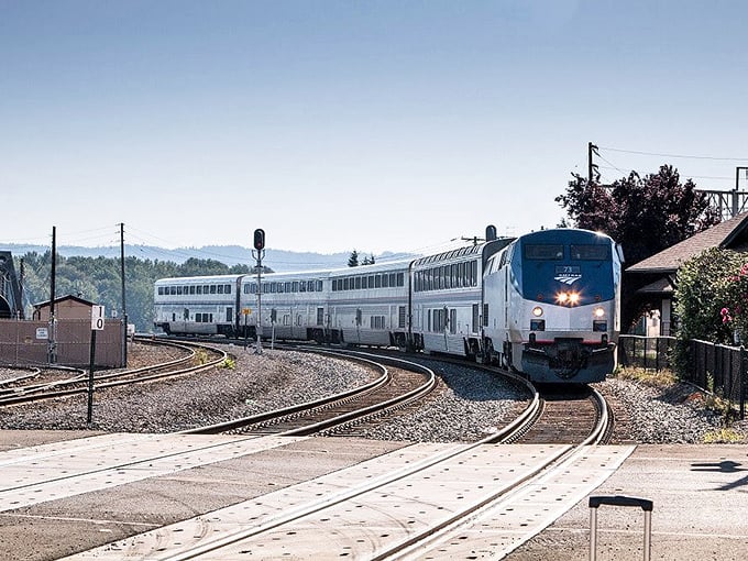The Empire Builder navigates a graceful curve, showcasing Amtrak's iconic blue and silver livery against Wisconsin's rural backdrop.