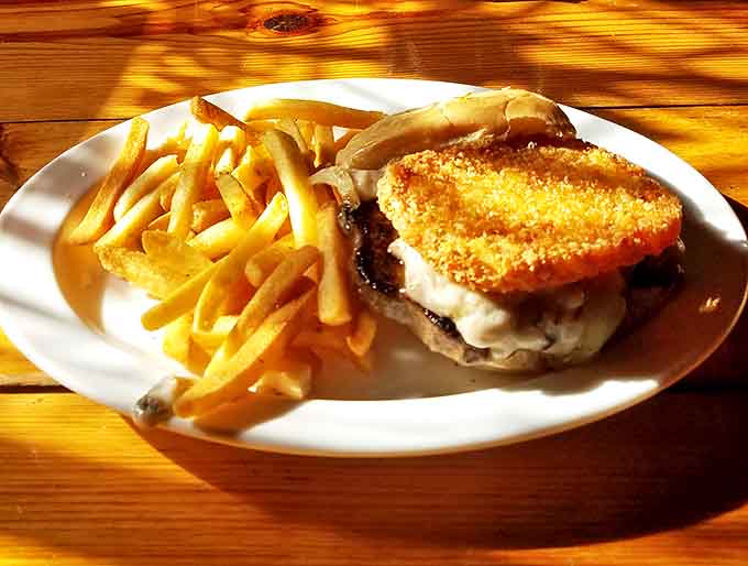 The patty melt arrives golden and glistening, a symphony of grilled bread, melted cheese, and seasoned beef that sings to your taste buds.