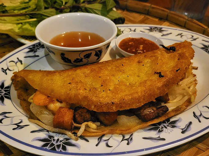 The Vietnamese Crepe arrives like an edible half-moon, crispy and golden, stuffed with treasures that make every bite a different adventure.