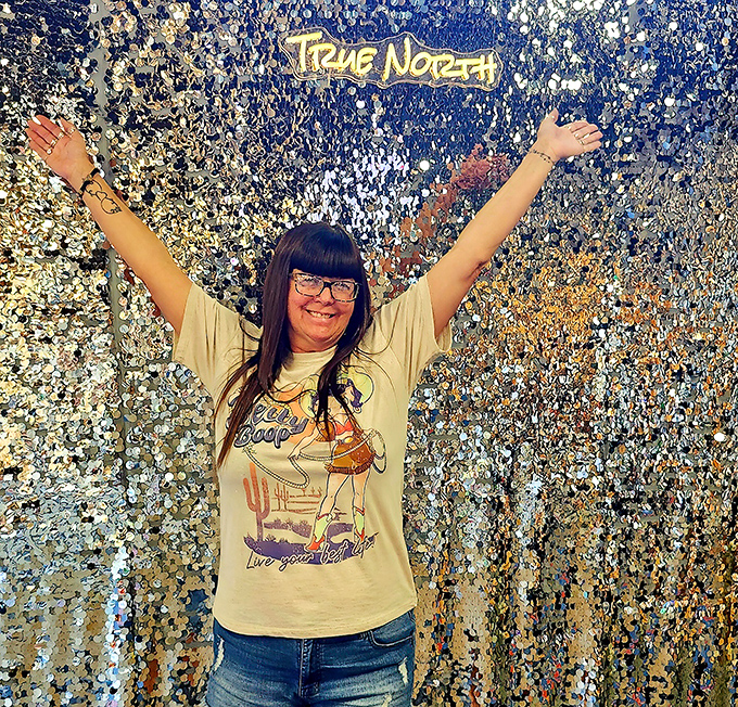 A visitor celebrates against a glittering backdrop – True North isn't just about shopping, it's about creating moments of joy and discovery.