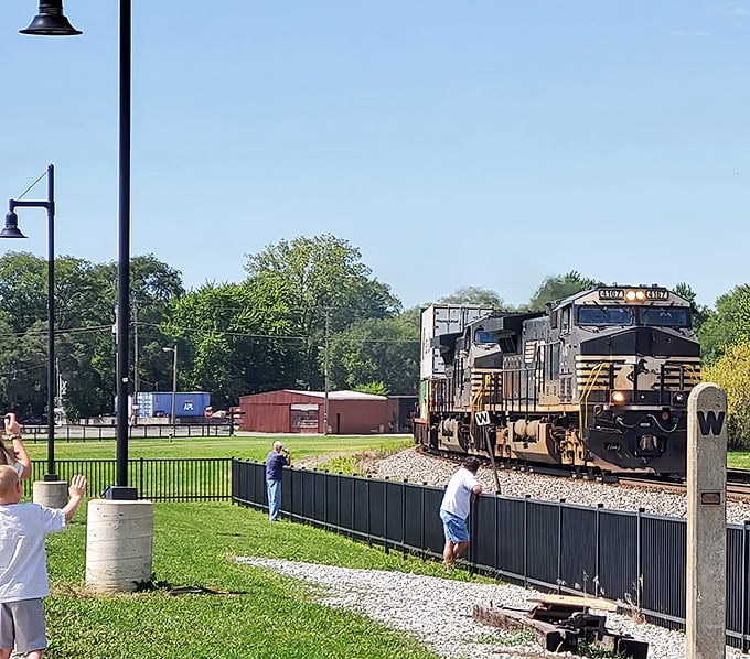 Visitors capture the moment as a powerful CSX locomotive thunders past, close enough to feel the rush of displaced air.