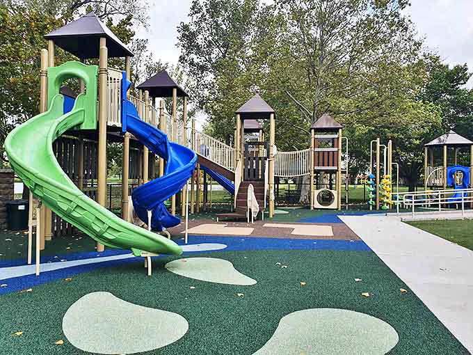 This playground paradise features twisting slides and climbing structures where kids burn energy while parents secretly wish they could join in.
