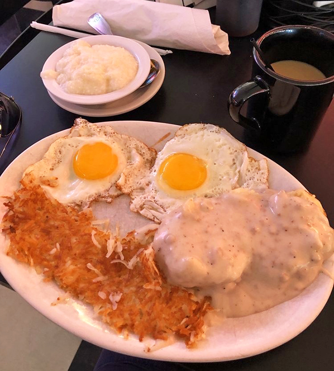 The holy trinity of breakfast perfection: golden hash browns, eggs with sunshine-yellow yolks, and that legendary gravy-soaked biscuit.