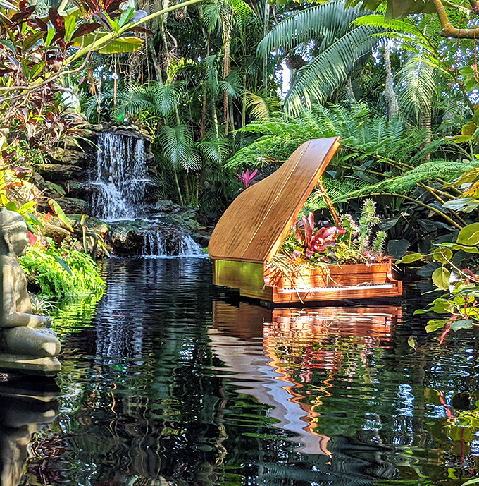 Botanical Scene: A wooden boat floats serenely on reflective waters, surrounded by tropical plants and a gentle waterfall &ndash; nature's own meditation space.