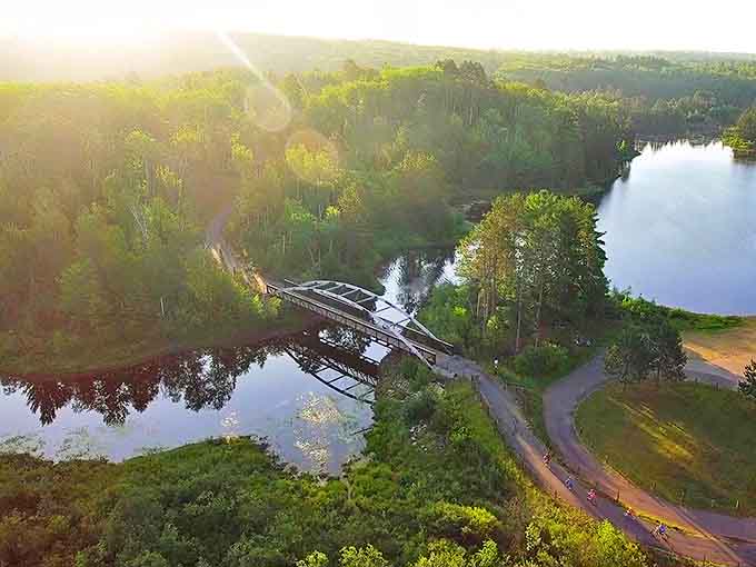 Morning mist hovers over still waters as the trail's bridges offer both passage and perspective on Minnesota's breathtaking landscape.