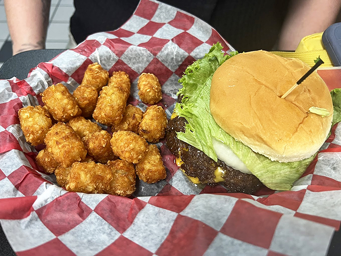 A perfect burger and golden tater tots served on classic red-checkered paper &ndash; proof that happiness doesn't need fancy plating or pretentious ingredients.