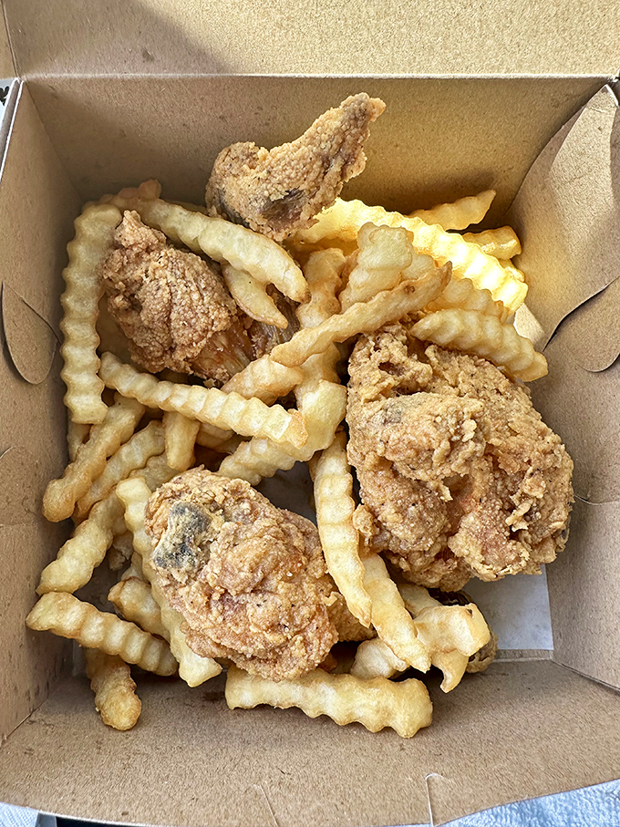 The humble cardboard box becomes a treasure chest when filled with Fast Eddie's crispy chicken and those perfect crinkle-cut fries.