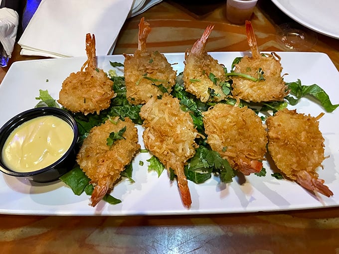 Golden-fried coconut shrimp that crunch like walking on perfect beach sand, with dipping sauce adding a sweet-tangy exclamation point.