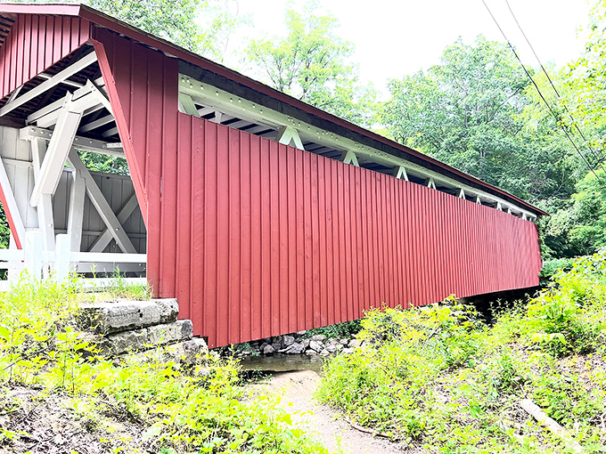 This historic covered bridge doesn't just span a creek &ndash; it bridges centuries, standing as a crimson reminder of simpler times.