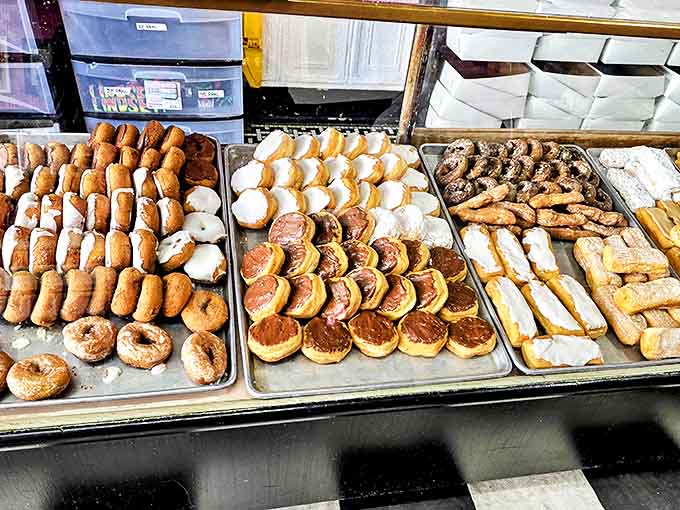 Trays of golden-brown donuts and pastries glisten under the display lights, each one a testament to old-world baking traditions.