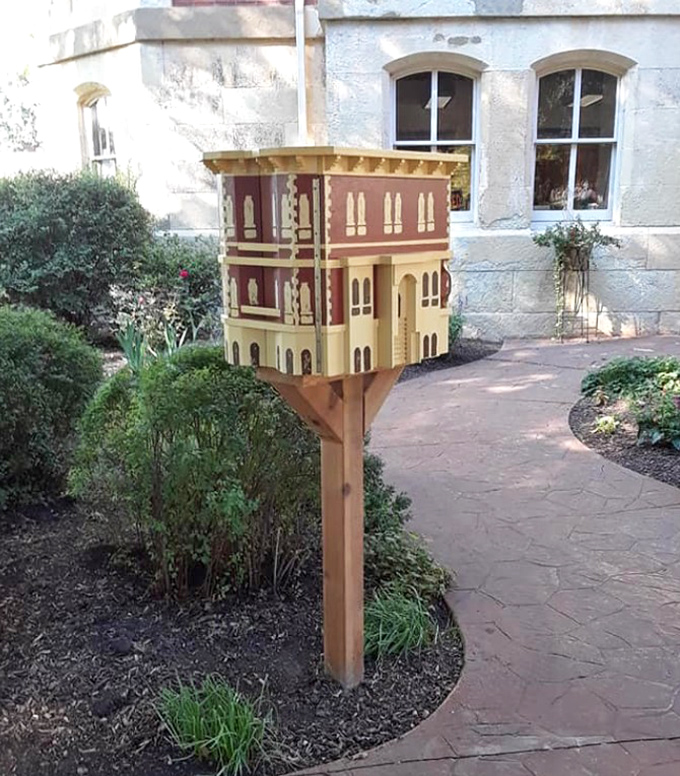 The cutest little architectural inception you'll ever see – a miniature Reddick Mansion serving as a Little Free Library on the grounds.