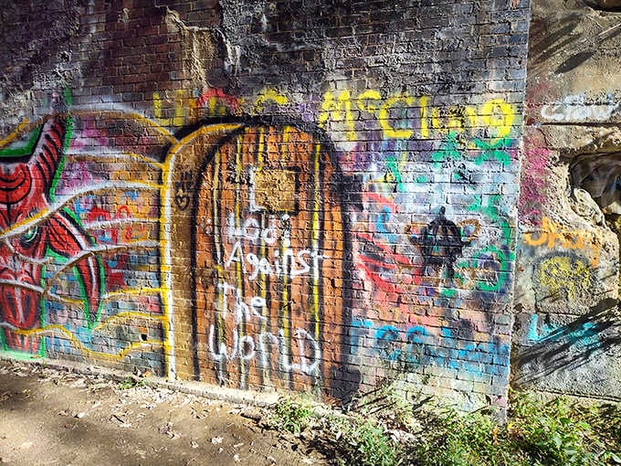 Urban art meets rural history as colorful graffiti transforms the tunnel's entrance into an ever-changing canvas.