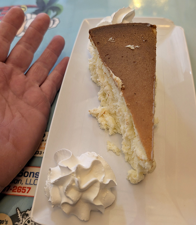 Behold the New York-style cheesecake in its natural habitat. That hand comparison isn't for scale&mdash;it's showing proper reverence.
