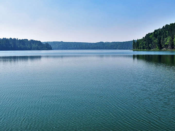 La Salle's crystal waters stretch to the horizon, reflecting the surrounding forest like a living painting that changes with every breeze.