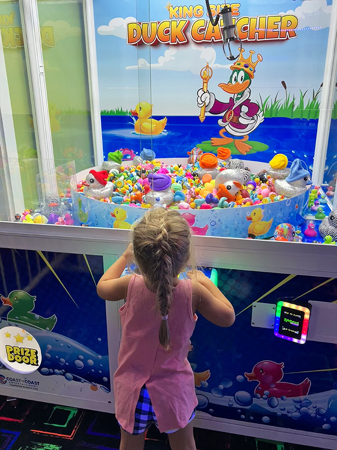 Little hands reach eagerly for prizes in the "King of the Duck Catcher" game &ndash; childhood joy captured in one determined stance.