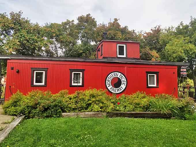 The crimson caboose stands proudly on display, its Northern Pacific Railway heritage preserved for railroad enthusiasts and curious travelers alike.
