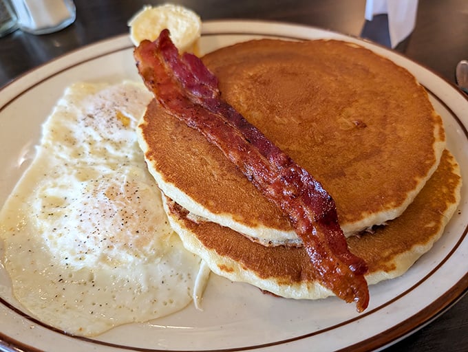 Golden pancakes with a strip of bacon standing at attention&mdash;the breakfast equivalent of a perfect day at the beach.