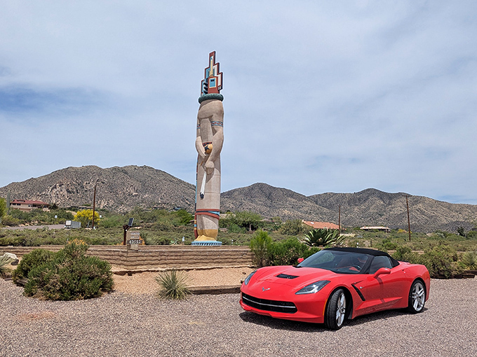 A sleek Corvette provides scale to the massive monument, showcasing why car enthusiasts love this photo stop.