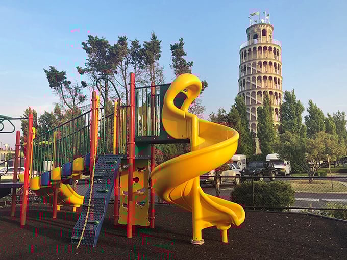 Childhood wonder meets architectural curiosity as the playground equipment stands in playful contrast to the towering Italian-inspired landmark behind it.