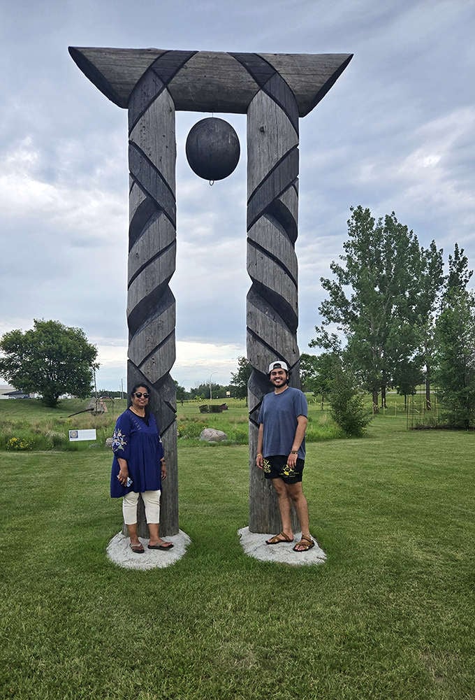Two spiral-carved wooden columns support a mysterious hanging sphere &ndash; part functional art, part cosmic question mark in the Minnesota landscape.