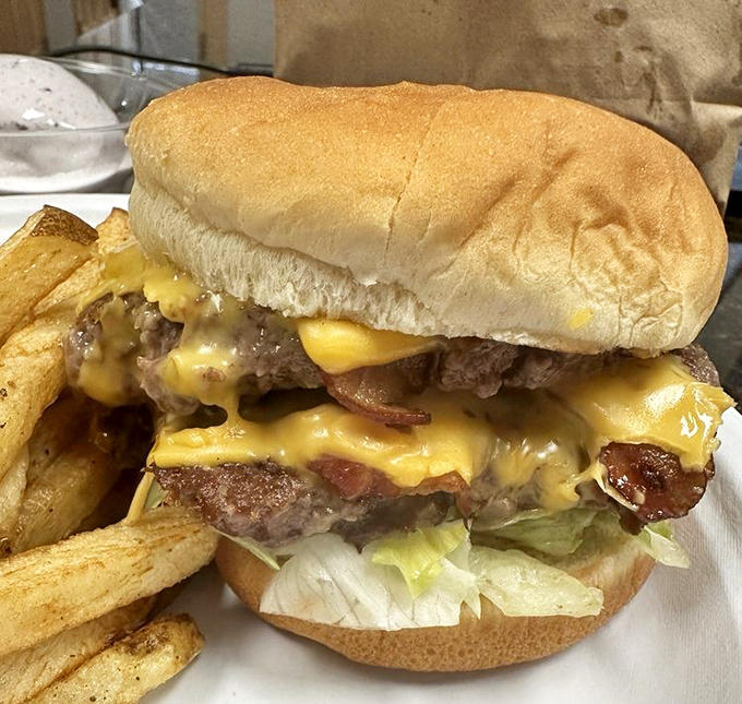 This double bacon cheeseburger isn't just a meal &ndash; it's an architectural marvel of beef, cheese, and bacon extending beyond the bun.
