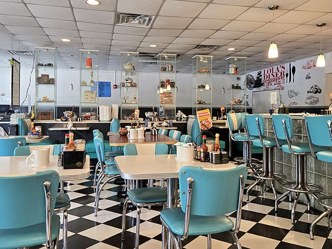 Turquoise chairs pop against the black and white checkered floor at Lola's, creating a classic 50s atmosphere that complements their comfort food perfectly.
