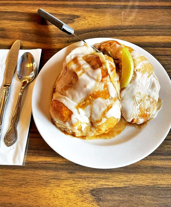 Apple Cinnamon Roll: A fresh apple slice crowns this cinnamon masterpiece, adding fruity brightness to the warm spice beneath. Fall in pastry form.