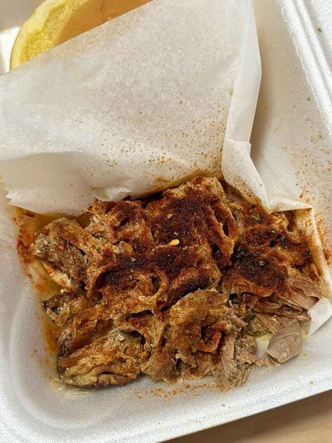 Pulled pork piled this high with those crispy burnt ends mixed in is the kind of sandwich that requires both hands and zero shame.