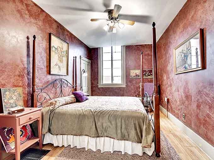 Rich burgundy walls embrace antique furnishings in this bedroom that feels like sleeping inside a glass of fine wine.