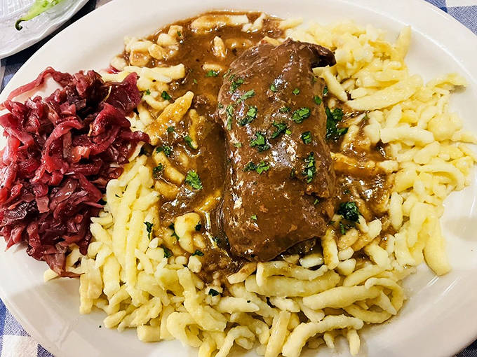 Beef rouladen nestled on a bed of sp&auml;tzle with red cabbage &ndash; a symphony of flavors that transports you straight to a Black Forest kitchen.
