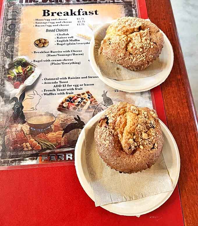 These aren't just muffins &ndash; they're small mountains of breakfast bliss, their crumbly tops promising sweet treasure within beside a tempting menu.