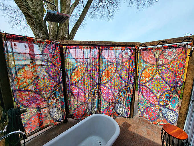 An outdoor bathtub surrounded by colorful curtains and potted plants proves that sometimes the best ideas are also the most wonderfully weird ones.