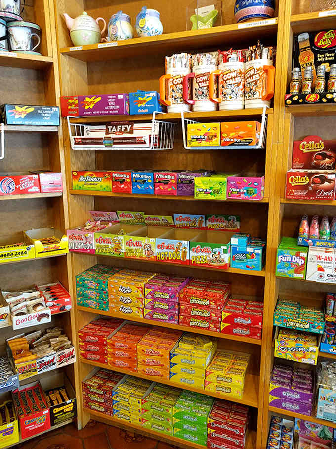 Wooden shelves overflow with boxed candies and nostalgic treats, creating a museum of sweetness where everything's for sale and touching is encouraged.