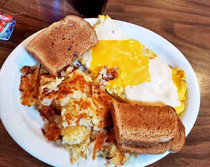 The classic American breakfast in its natural habitat &ndash; eggs cooked just right, toast ready for butter adventures, and hash browns that deserve their own fan club.