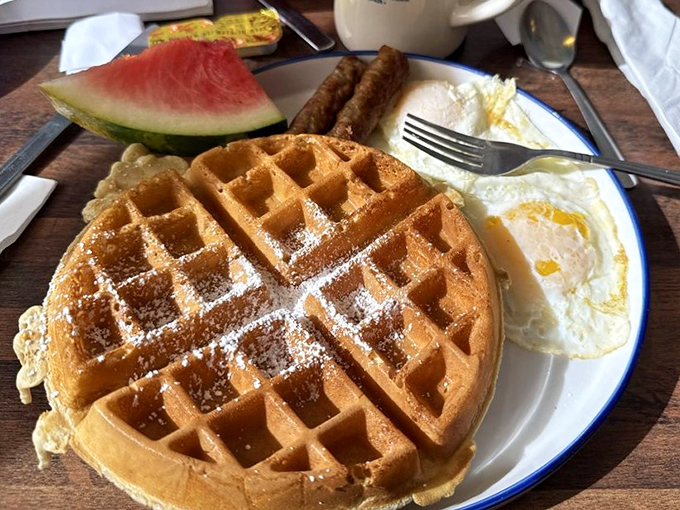 The classic breakfast done right: golden waffle, perfectly cooked eggs, and sausage links that snap when you bite them.